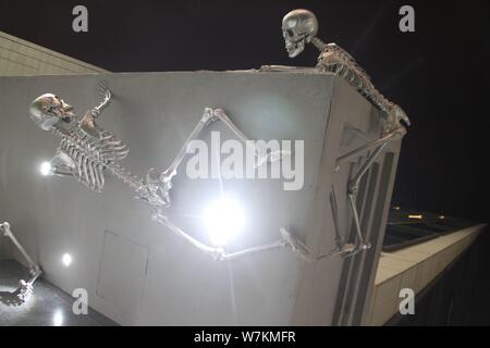 Skeleton sculptures climb a shopping mall to attract customers in Ji ...