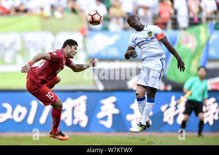 Festus Baise of Guizhou Hengfeng heads the ball against Jiangsu Suning ...