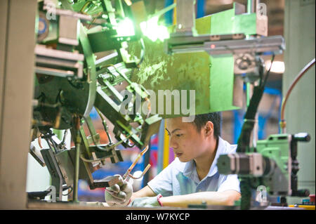 A Chinese worker assembles air conditioners on the production line at a ...