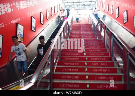 Passengers walk on stairs installed with infrared ray detectors to ...