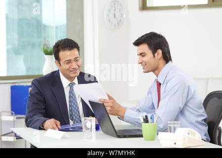 Financial advisor explaining on document to a client Stock Photo - Alamy