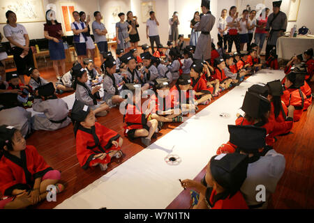 Students write the Chinese character "Ren," meaning "Human" in English ...