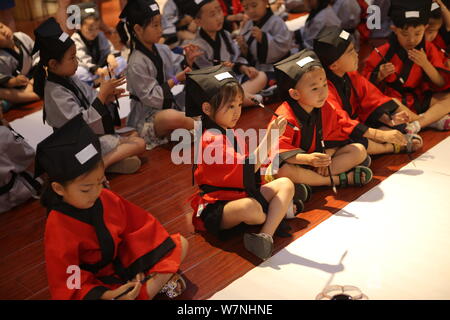 Students write the Chinese character "Ren," meaning "Human" in English ...
