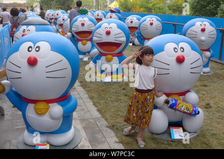 A visitor takes photos with models of Doraemon, a famous Japanese ...