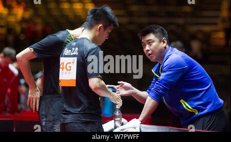 Coach Wang Hao of the Chinese national men's table tennis team, right, instructs his players Fan ...