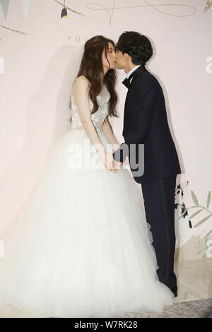 Taiwanese singer Yoga Lin, right, kisses his singer wife Kiki Ting ...