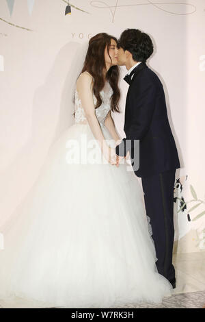 Taiwanese singer Yoga Lin, right, kisses his singer wife Kiki Ting ...