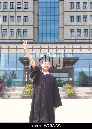 A Chinese graduate dressed in an academic gown arrives at a graduation ...