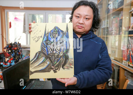 Chinese Transformers fan Wang Geng shows a poster of the movie ...
