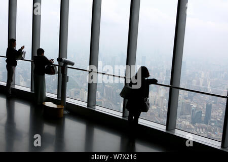 Visitors look at the cityscape of Shanghai in the sightseeing ...