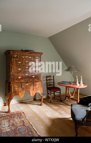 Chest of drawers, floor lamp and table in interior of living room Stock ...
