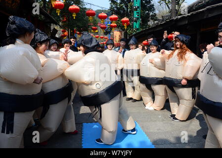 Chinese women dressed in inflatable sumo-wrestler costumes take part in ...
