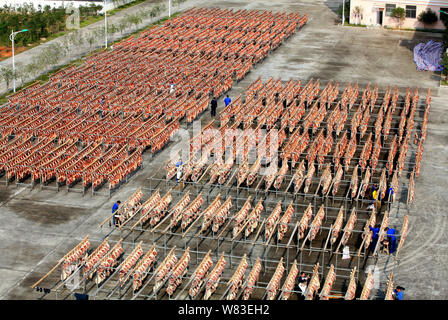 Chinese workers hang Jinhua hams to dry them in the sun in a factory of ...