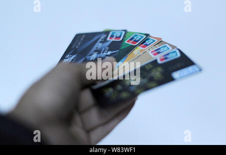 --FILE--A Chinese resident shows his debit cards and other bank cards ...