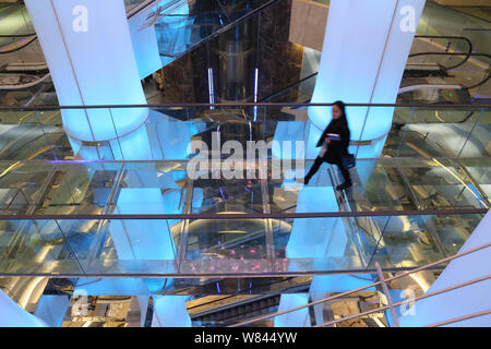 A Chinese student walks through a glass bridge in the new library at ...