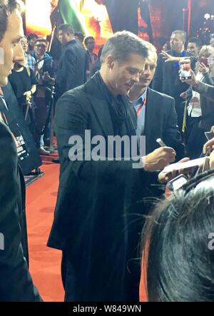 Brad Pitt signs autographs as he arrives for the premiere of the film ...