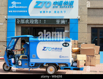 A Chinese courier drives a delivery vehicle of SF Express to delivery ...