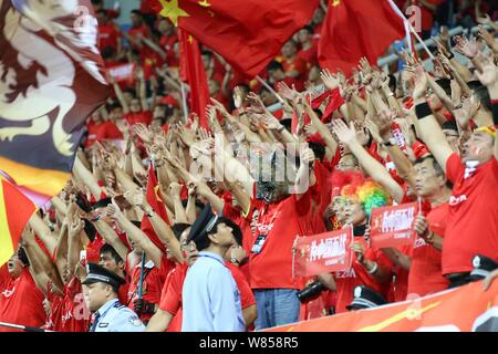 Chinese football fans wave national flags and shout slogans to show ...