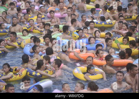 Chinese holidaymakers crowd a swimming pool at a water park to escape ...
