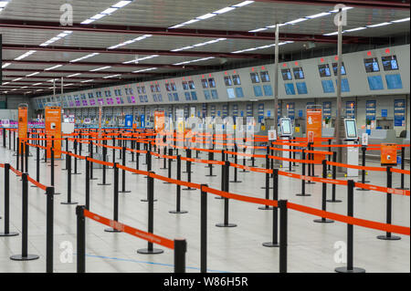 London Luton Airport, UK, check-in hall. Wizz Air passengers queue to ...