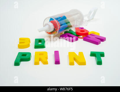 a plastic syringe full of plastic letters and numbers next to some ...