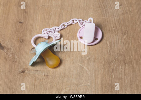 Pink baby pacifier on a blue background, space for text Stock Photo - Alamy