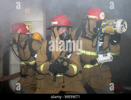 Sailors fight a simulated fire during a mass casualty drill in the ...