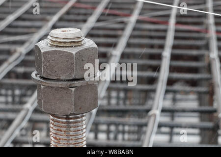 Steel anchor bolt with screw nut and steel grid on tower crane footing ...