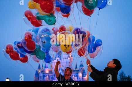 Employees sell Mickey Mouse balloons in Disneytown at the Shanghai ...