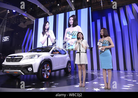Chinese singer Zhang Liangying, left, poses with a Subaru Viziv Future ...