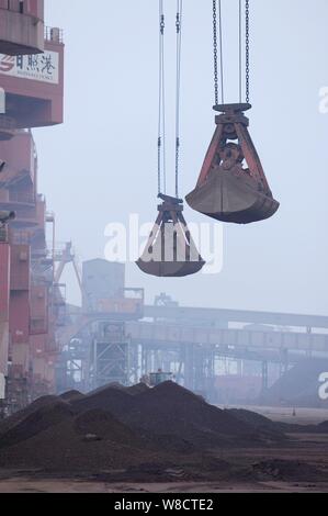 --FILE--Grab buckets unload iron ore on a quay at the Port of Rizhao in ...