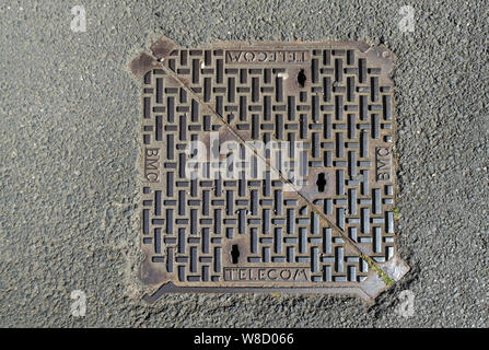 Close-up of telecommunications manhole cover with logo for telephone ...