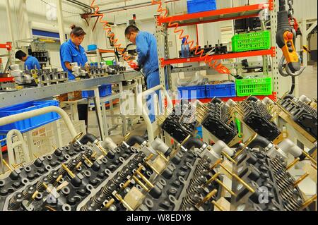 --FILE--Chinese workers assemble engines for autos at a plant of ...