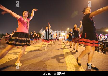 --FILE--Local Chinese women dance on a square in the evening in Huaian ...