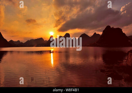View of sunset over the Chenglong Lake in Luocheng Mulao Autonomous ...
