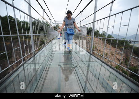 Visitors walk on the 180-meter-high and 300 meter-long glass-bottomed ...