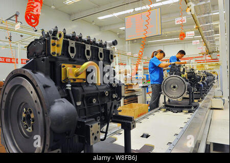 --FILE--Chinese workers assemble engines for autos at a plant of ...