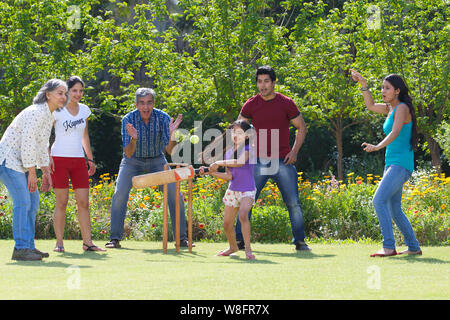 Family playing cricket in lawn Stock Photo - Alamy