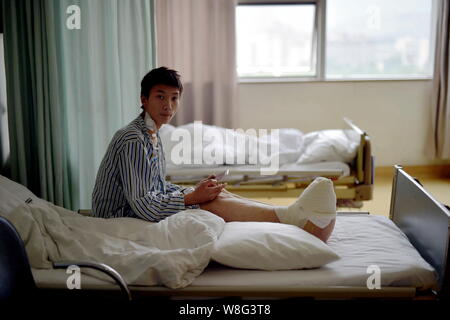 Liu Huichang who suffers from local gigantism sits on the bed after the ...