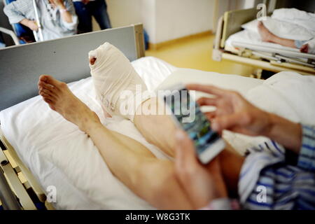 Liu Huichang, who suffers from local gigantism, uses his smartphone on ...
