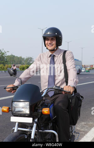 Sales executive riding a motorcycle Stock Photo - Alamy