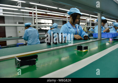 --FILE--Chinese workers assemble smart watches on the assembly line at ...