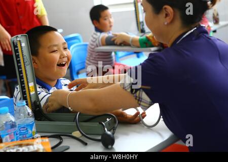 Chinese workers measure blood pressures of obese young students during ...
