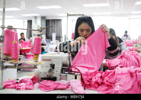 --FILE--A female Chinese worker sews clothes at a garment factory in Yichang city, central China ...