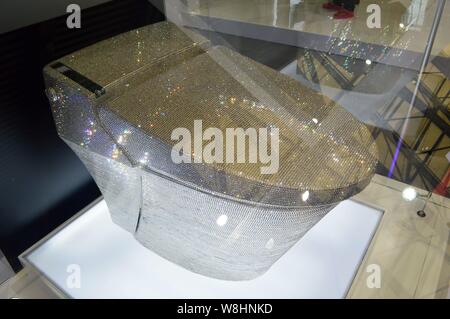 A flush toilet decorated with 72,000 Swarovski crystals is on display ...