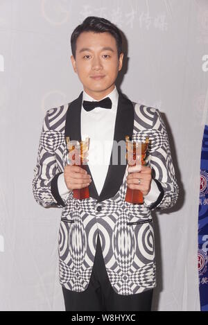 Chinese actor Tong Dawei poses with his trophies during the 17th ...
