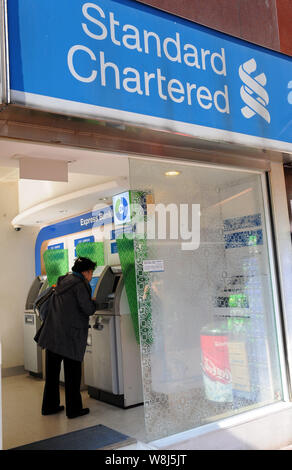 --FILE--A customer uses an ATM machine at a branch of Standard ...