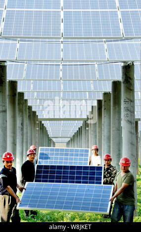 FILE - Workers install panels at a solar project May 21, 2025, in ...