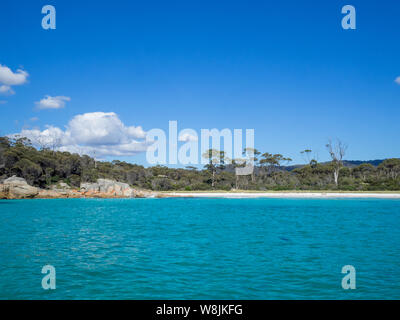 Turquoise waters, red lichen covered rocks and bush of the Bay of Fires ...