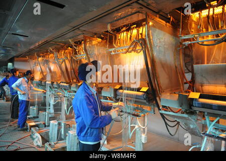 --FILE--Chinese workers manufacture fibreglass at a plant of China ...
